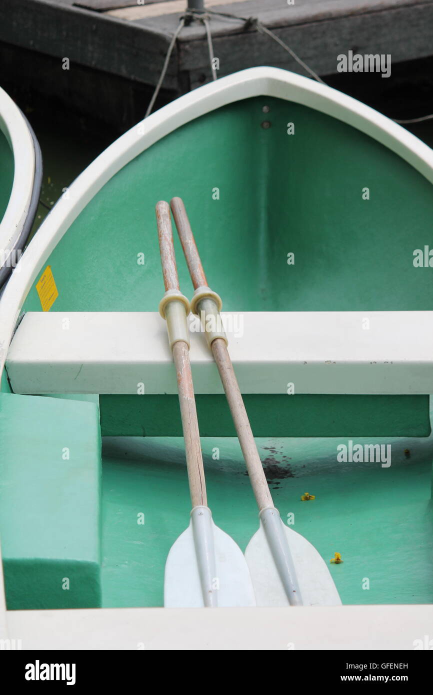 small green row boat with paddles oars and seat ready to explore ...