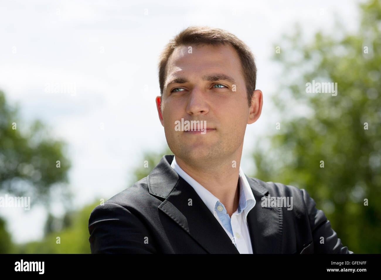 Close-up portrait of a young business man in a dark suit and white ...