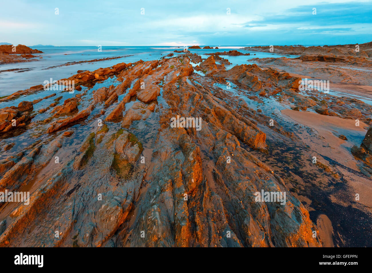 Twilight ocean coast with ribbed stratiform rock formations (Atlantic ...