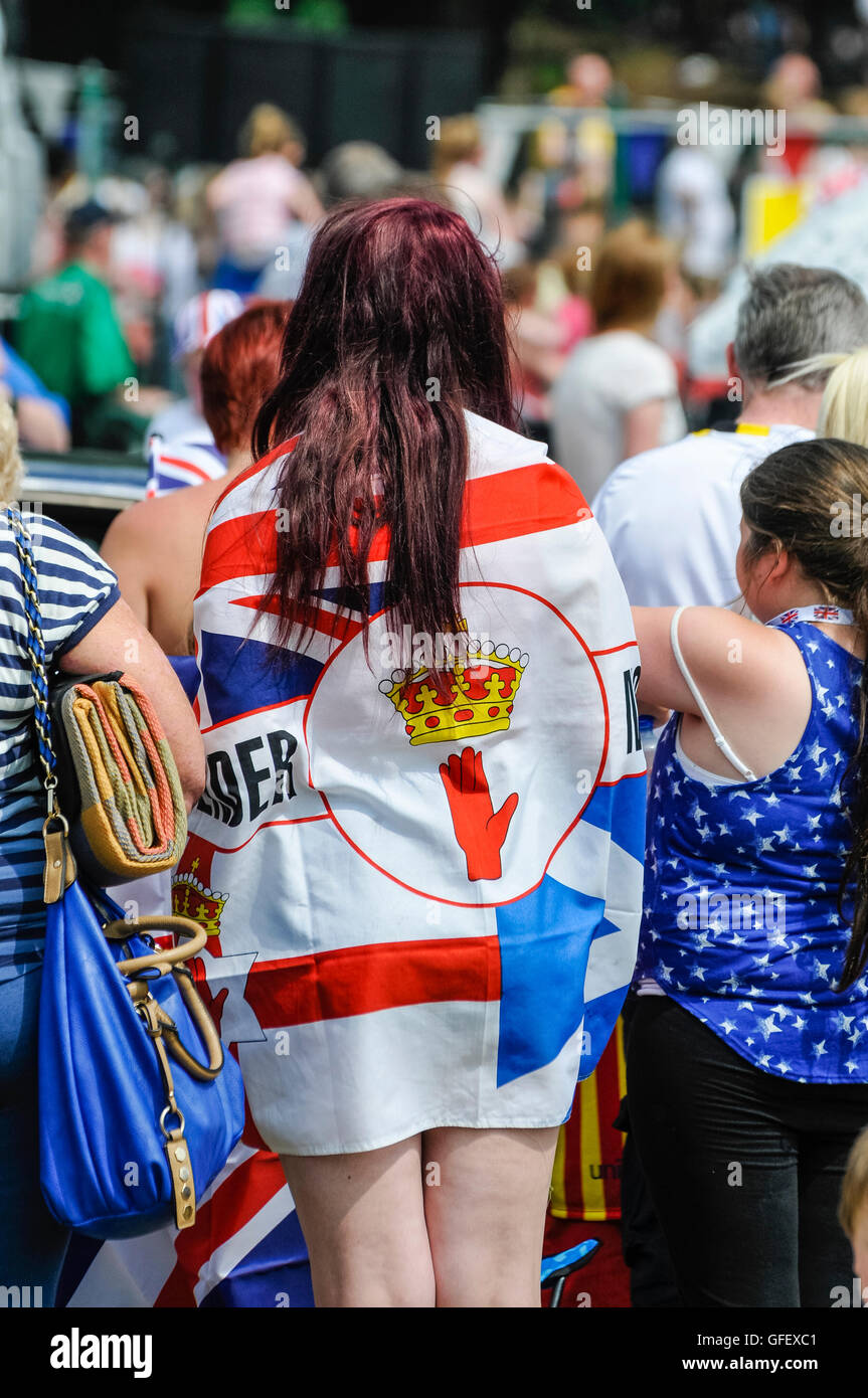 A young girl watches the parade wearing a large flag Stock Photo - Alamy
