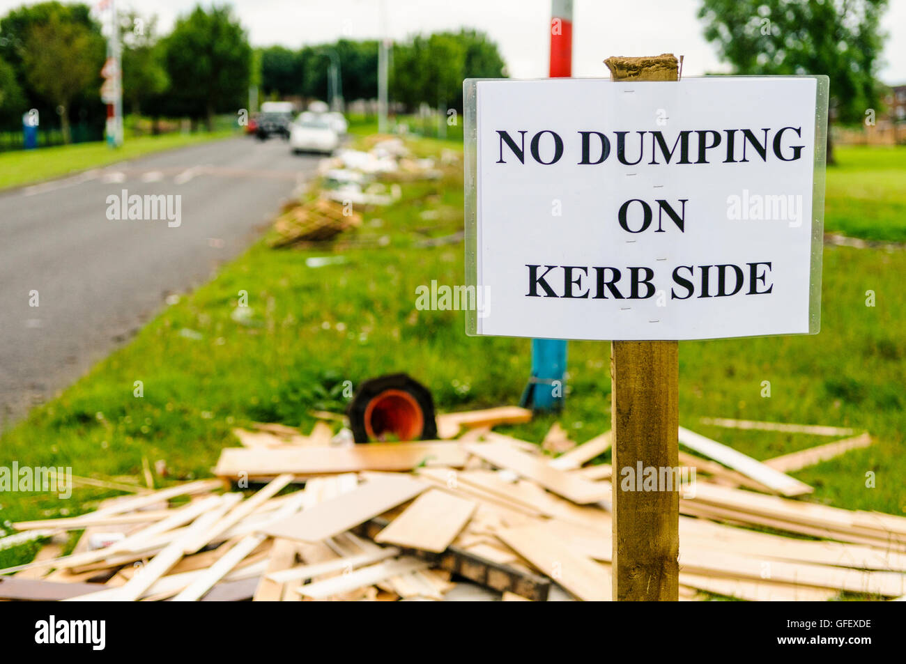 A sign on a grass verge warning people not to dump rubbish on the kerb ...