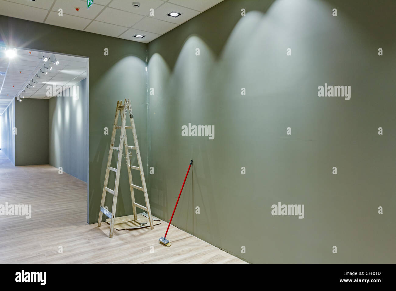 Workers are used wooden ladder to complete modern office ceiling with ...