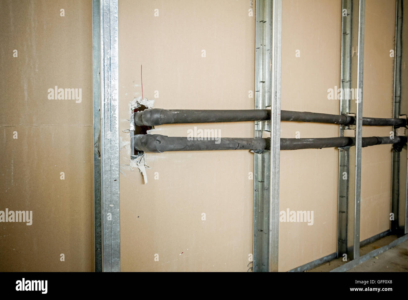 View at unfinished thermal partition dry wall with water pipeline going ...