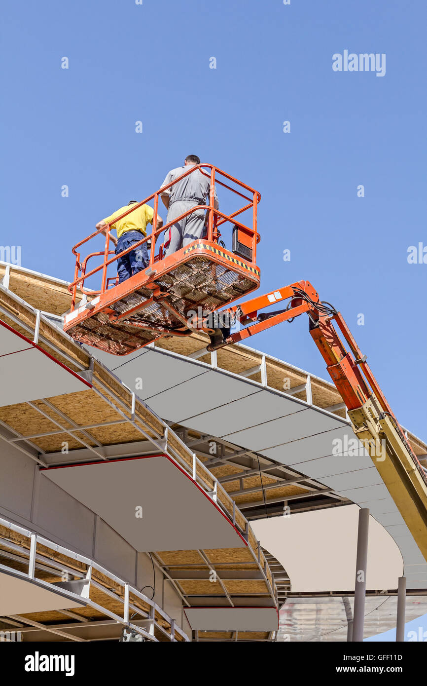 High elevated cherry picker people are working at new assembled ...