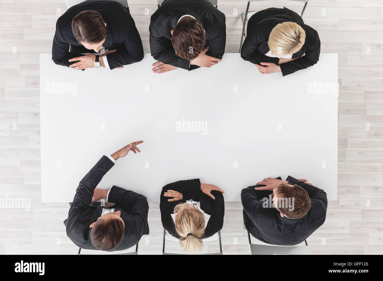 Business team sitting around white table, white copy space Stock Photo ...