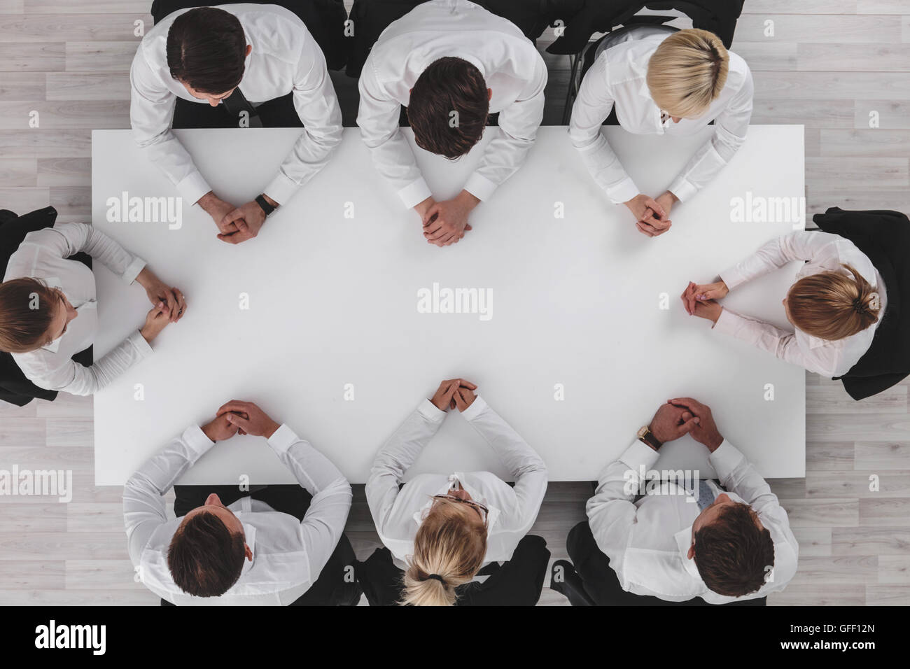 Business team sitting around white table, white copy space Stock Photo ...