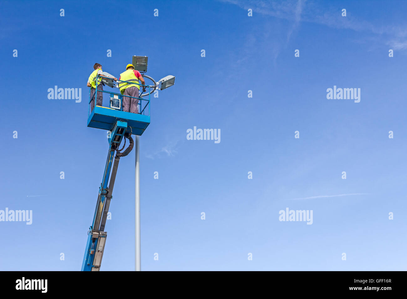 High elevated cherry picker with team of workers on floodlight Stock ...
