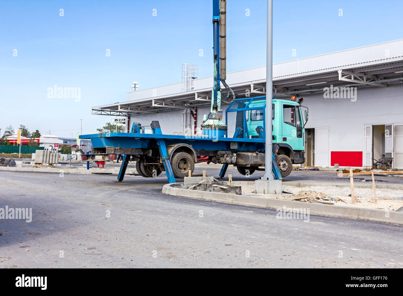 Truck with elevated bucket has lateral stabilizer extended to make ...