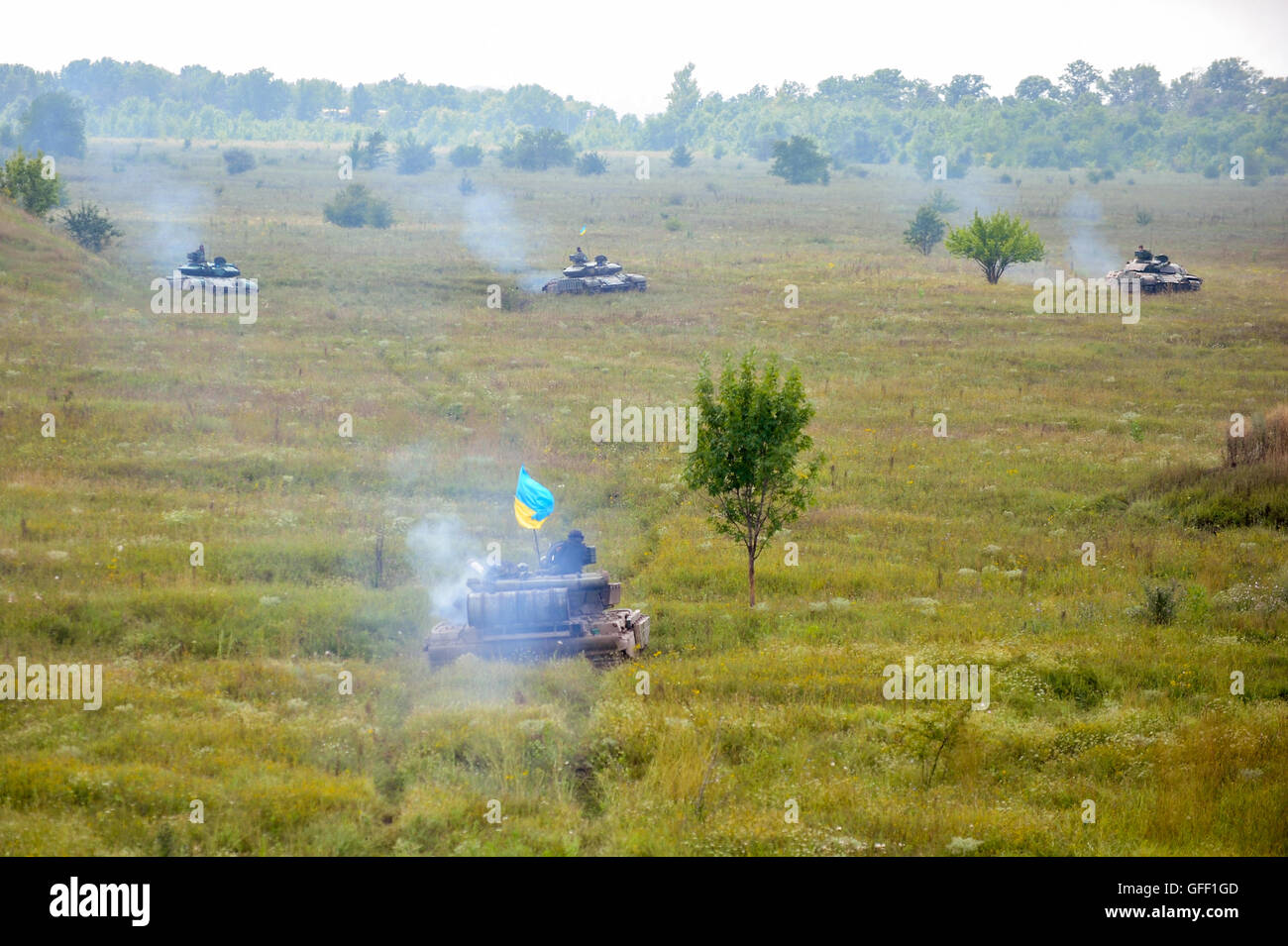 Main battle tank under the Ukrainian flag at a firing range in summer ...