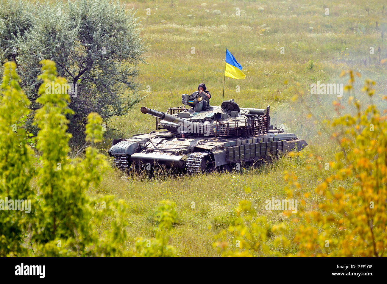 Main battle tank under the Ukrainian flag at a firing range in summer ...