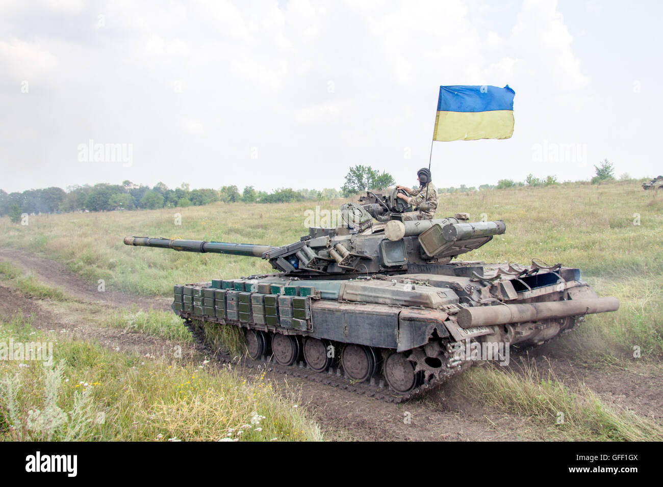 Main battle tank under the Ukrainian flag at a firing range in summer ...