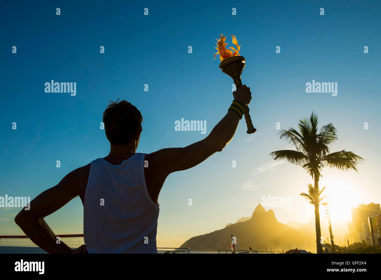 Silhouette of torchbearer athlete standing with sport torch in front of ...