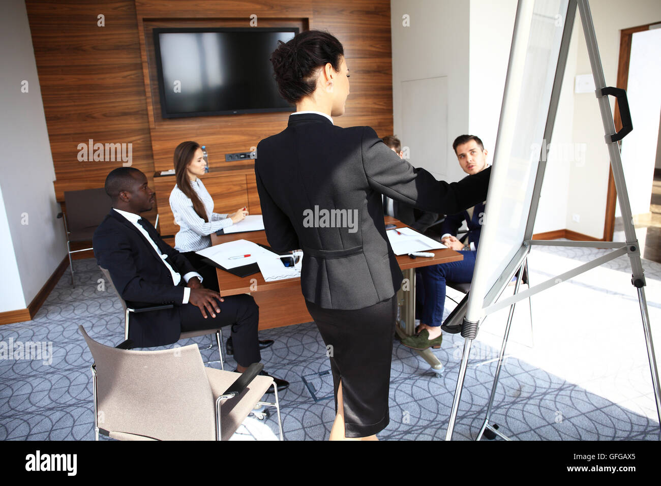 Woman making business presentation to a group Stock Photo - Alamy