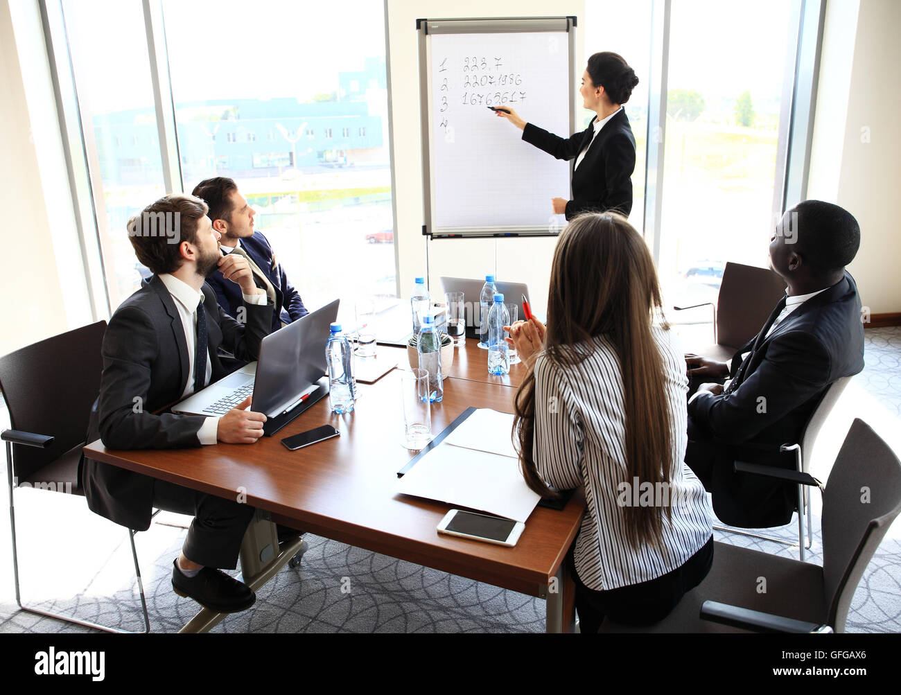 Woman making business presentation to a group Stock Photo - Alamy