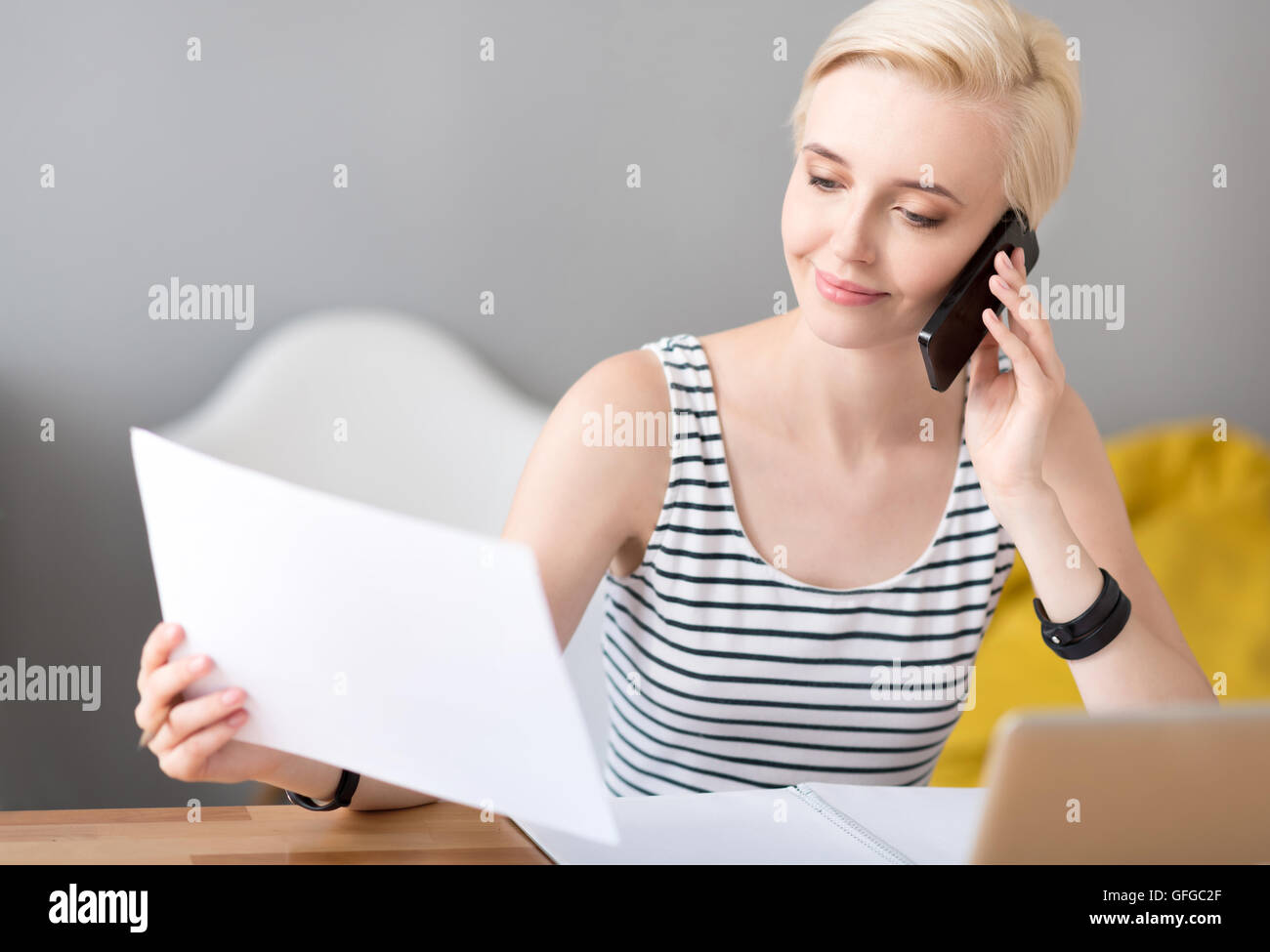 Woman looking at paper and talking Stock Photo - Alamy