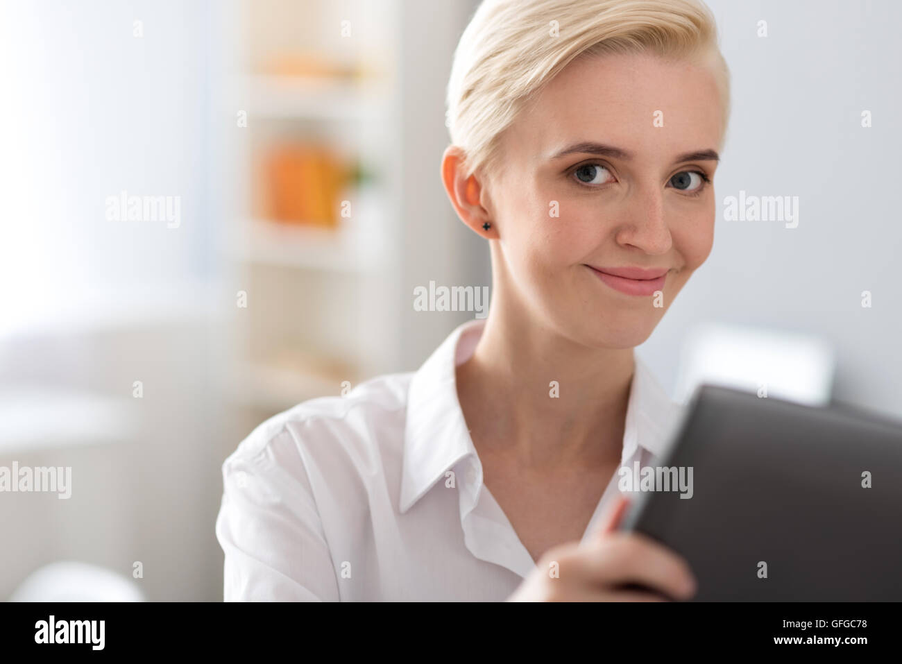 Woman with tablet looking at camera Stock Photo - Alamy
