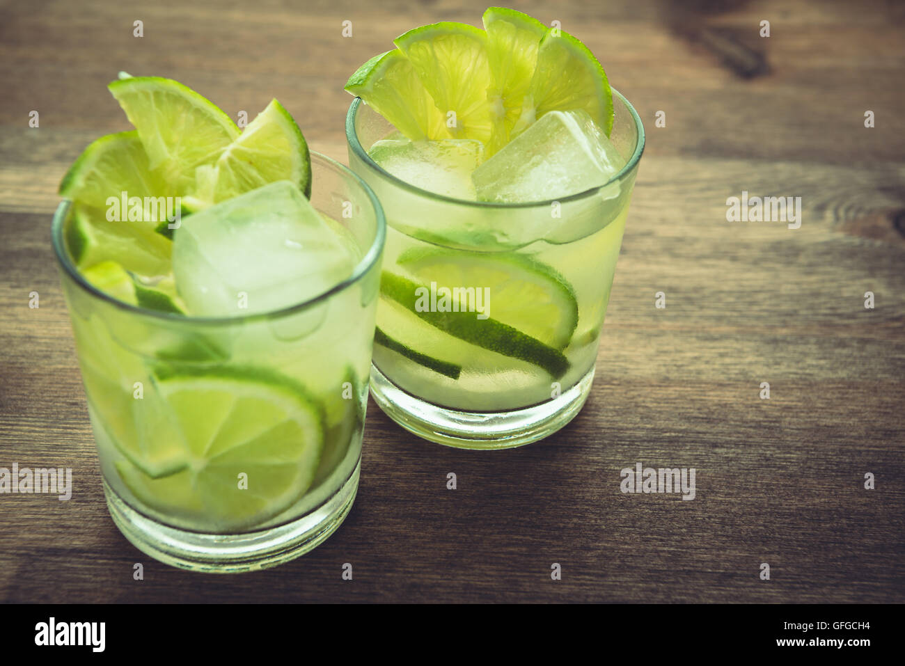 Still life of lime infused drinks on wood table top Stock Photo - Alamy