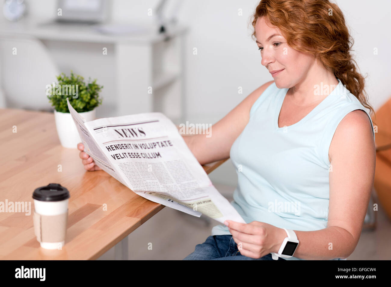 Pleasant woman reading newspaper Stock Photo - Alamy