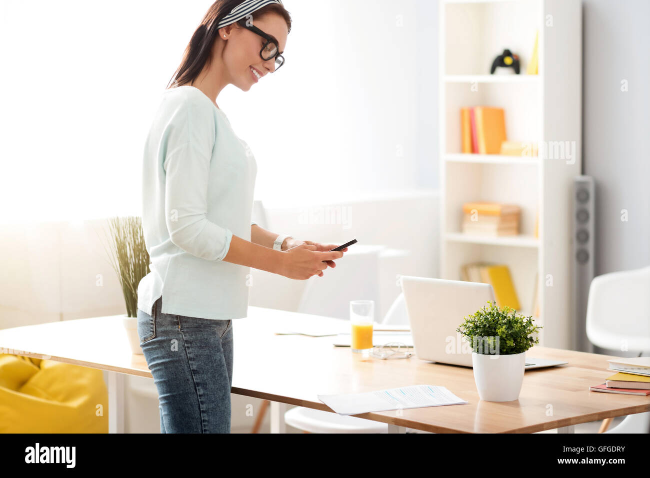 Joyful smiling woman standing near table Stock Photo - Alamy