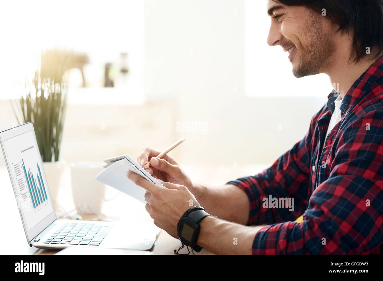Positive smiling man making notes Stock Photo - Alamy