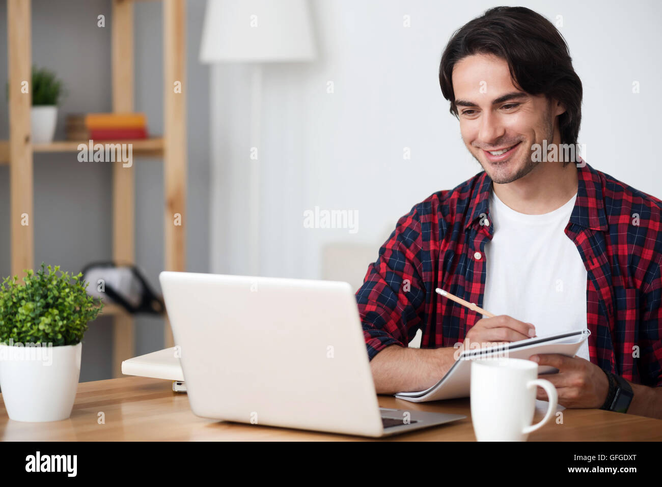Cheerful man making notes Stock Photo - Alamy