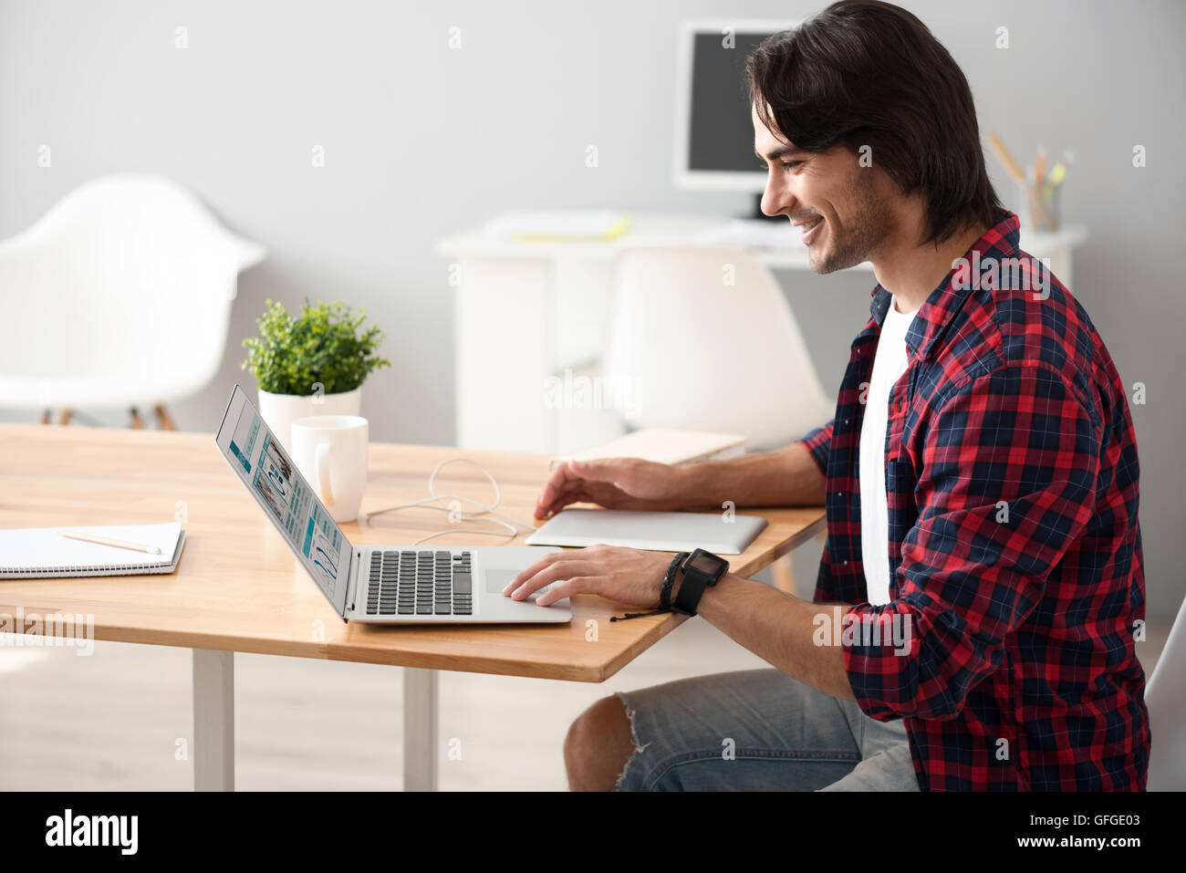 Positive man using laptop Stock Photo - Alamy
