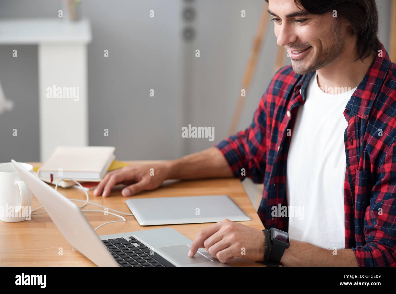 Positive man using laptop Stock Photo - Alamy