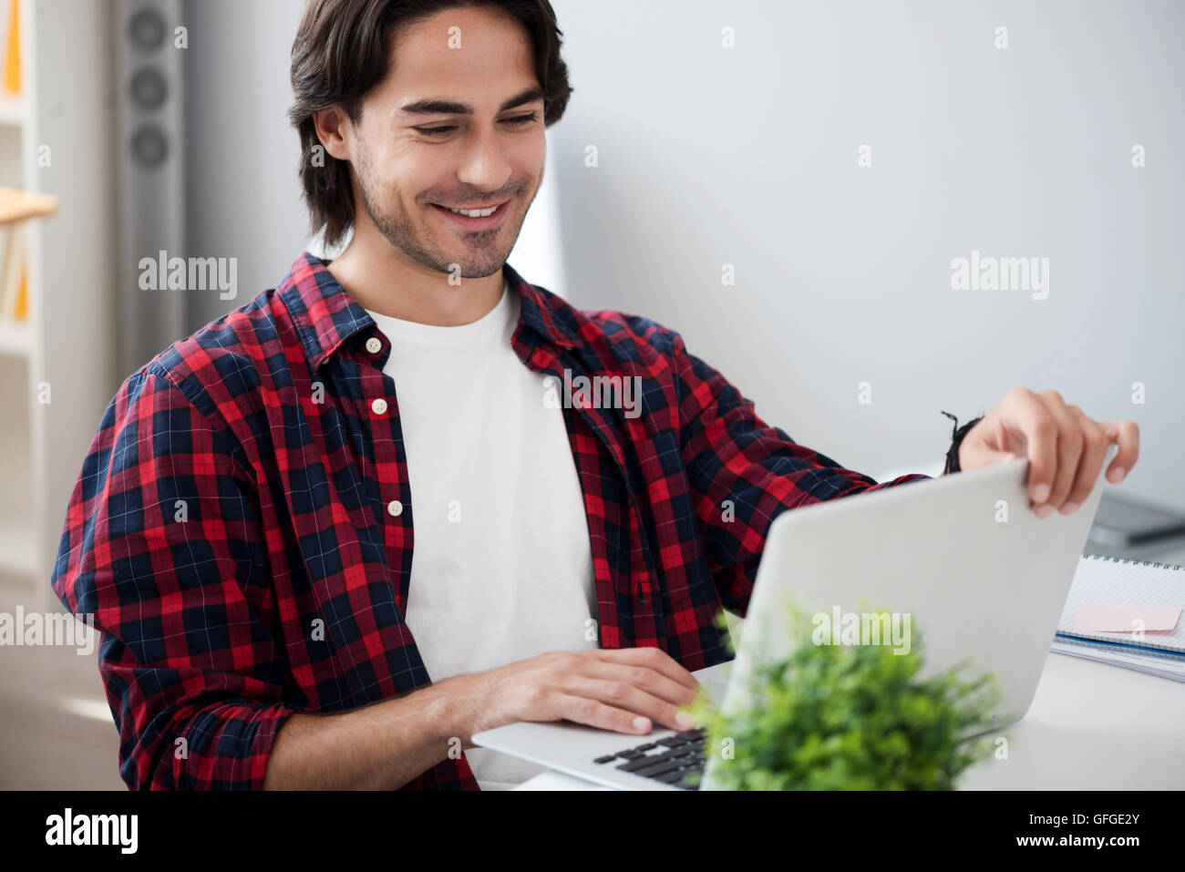 Positive man using laptop Stock Photo - Alamy