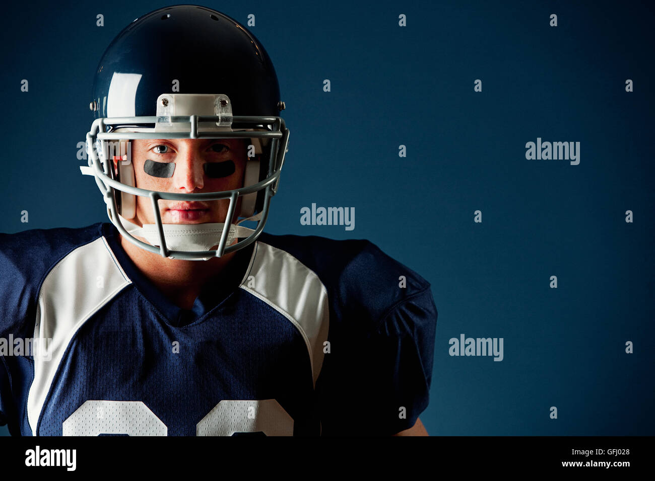 American football player, in uniform, on a blue background Stock Photo ...