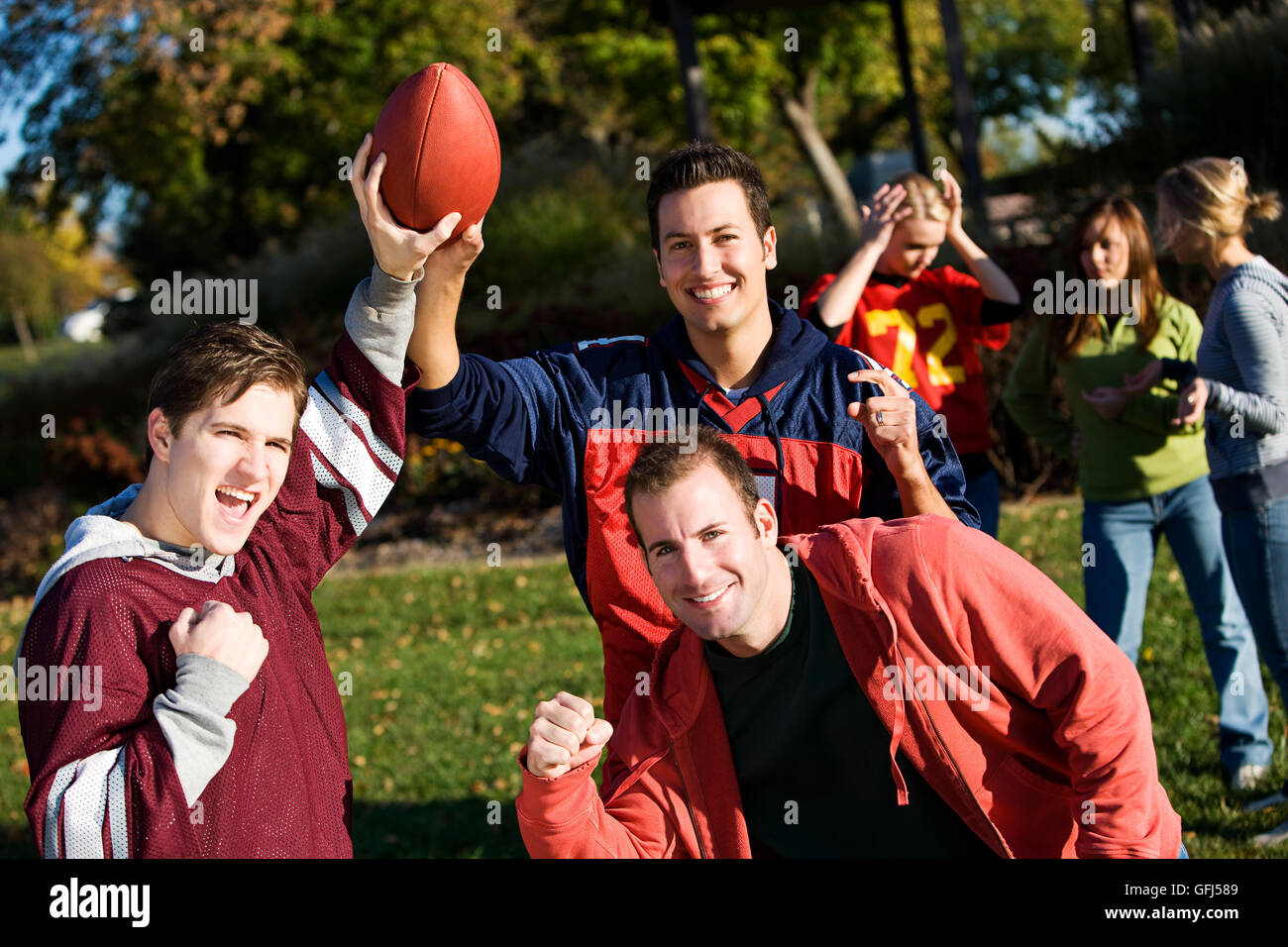 Series of a group of friends playing football in the park on an Autumn ...