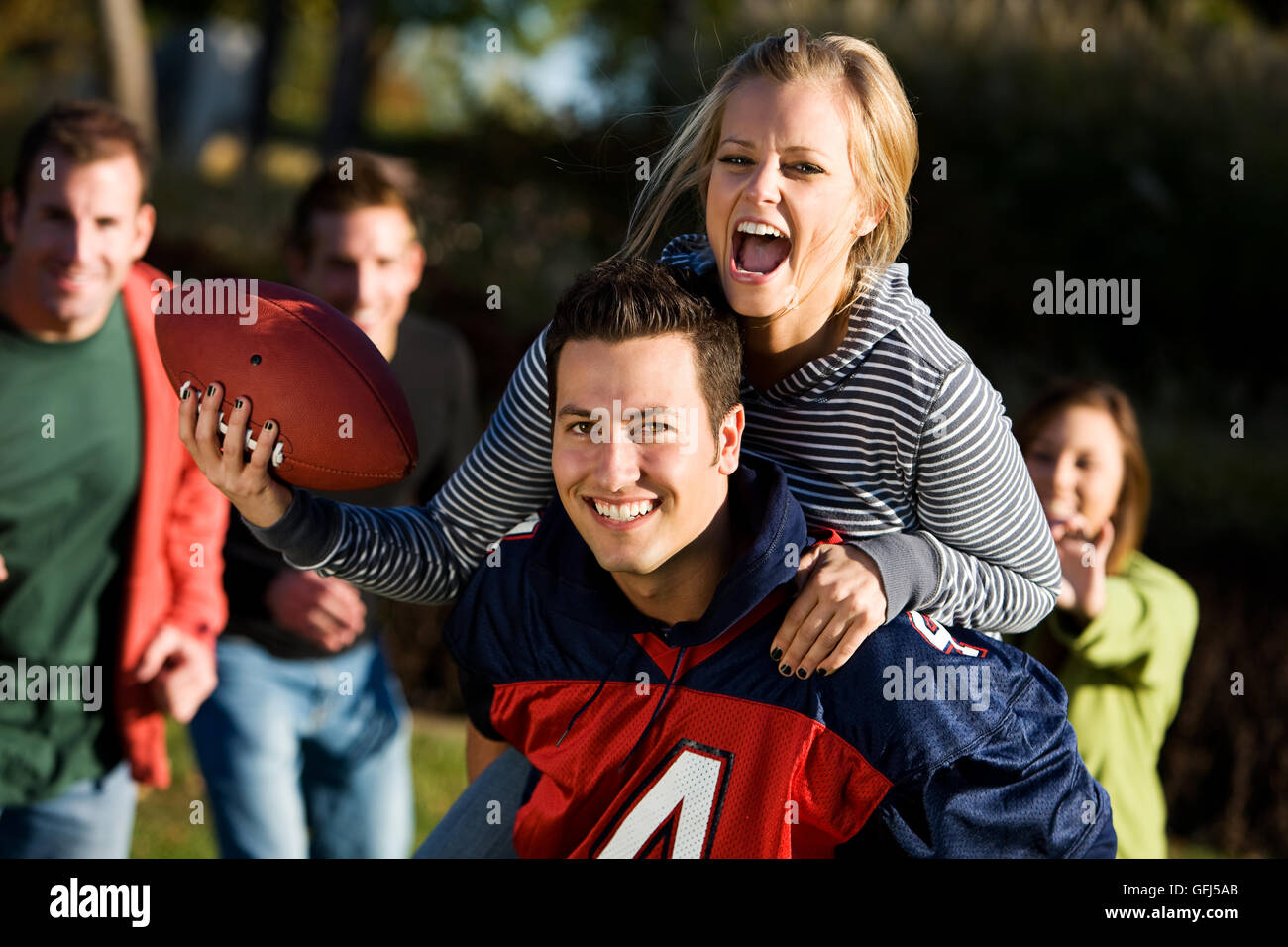 Series of a group of friends playing football in the park on an Autumn ...