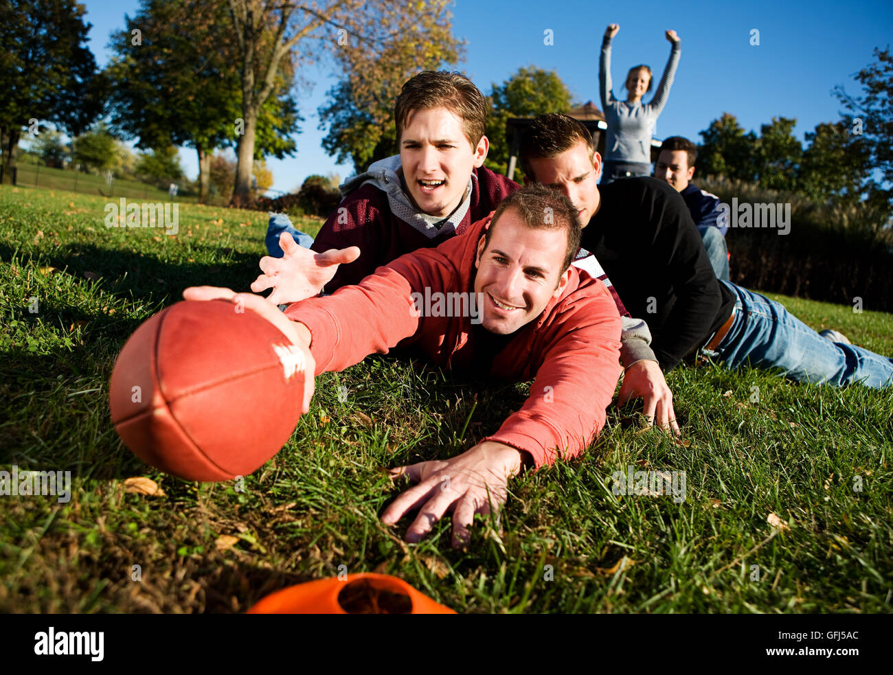 Series of a group of friends playing football in the park on an Autumn ...