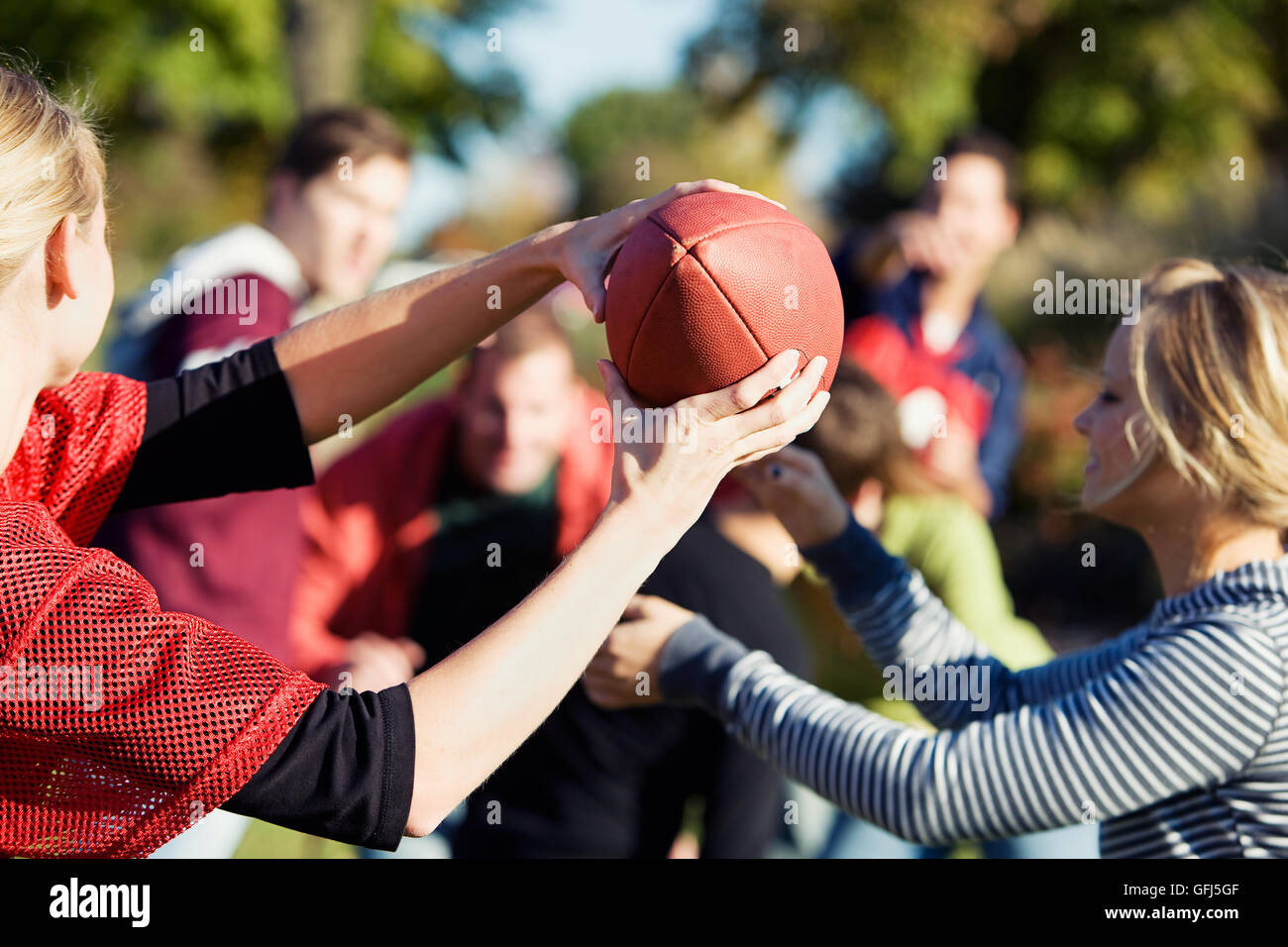 Series of a group of friends playing football in the park on an Autumn ...