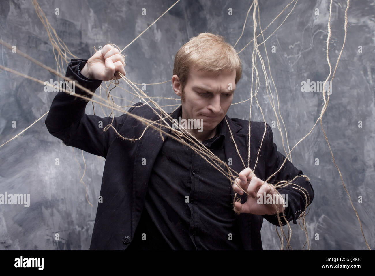 Young man tries to break the shackles. Concept of manipulation and ...