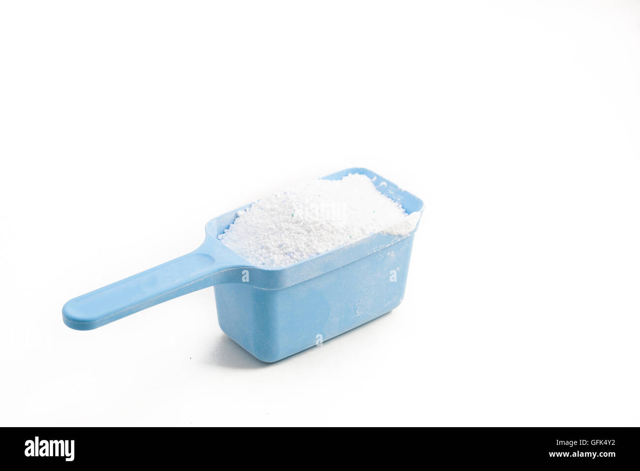 Laundry detergent, washing powder in a plastic blue spoon on white ...