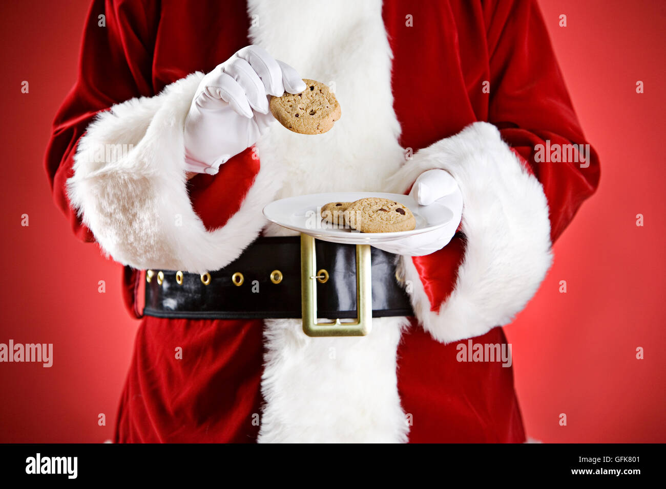 Anonymous Santa Claus on a red background holding various props, gifts ...