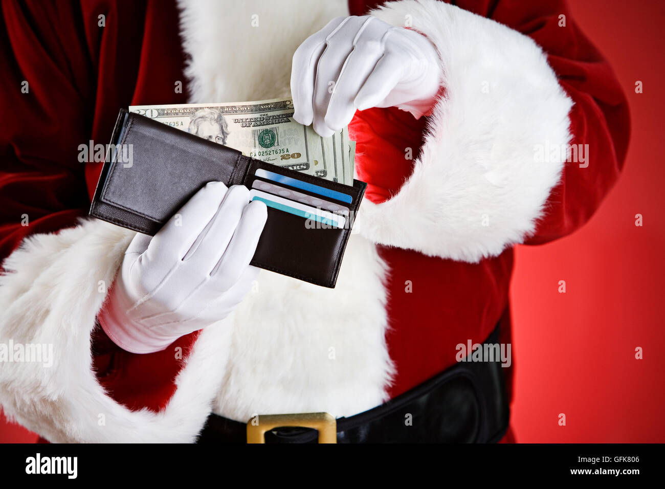 Anonymous Santa Claus on a red background holding various props, gifts ...