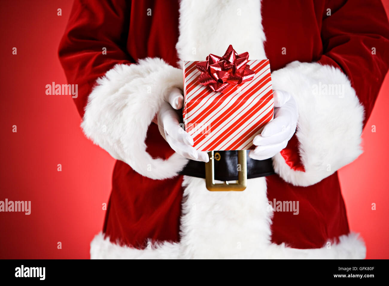 Anonymous Santa Claus on a red background holding various props, gifts ...