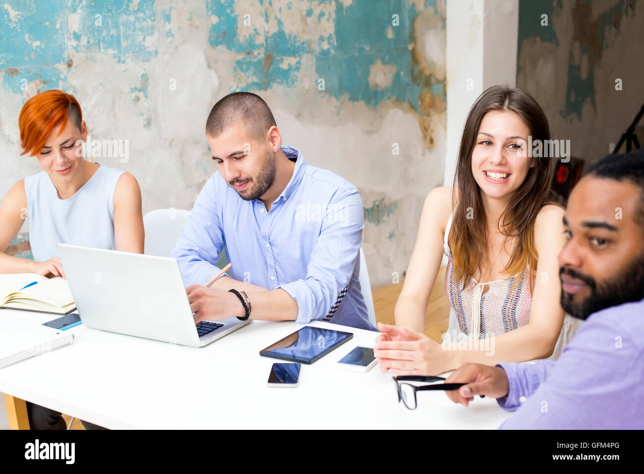Young people working by the desk in the grunge office Stock Photo - Alamy