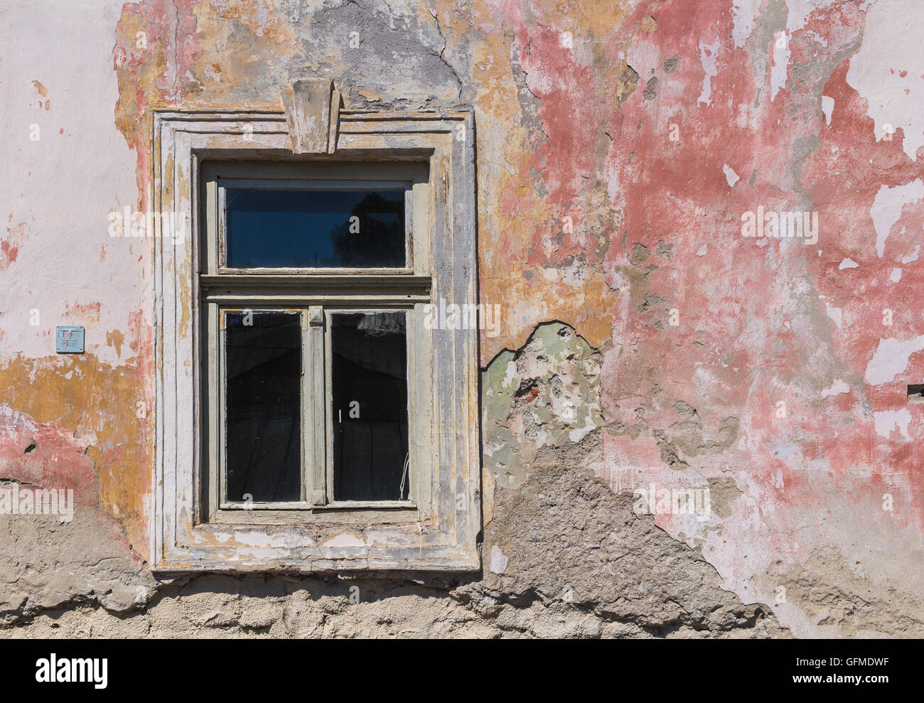 Window of an old abandoned house. Still with glass. Colorful facade ...