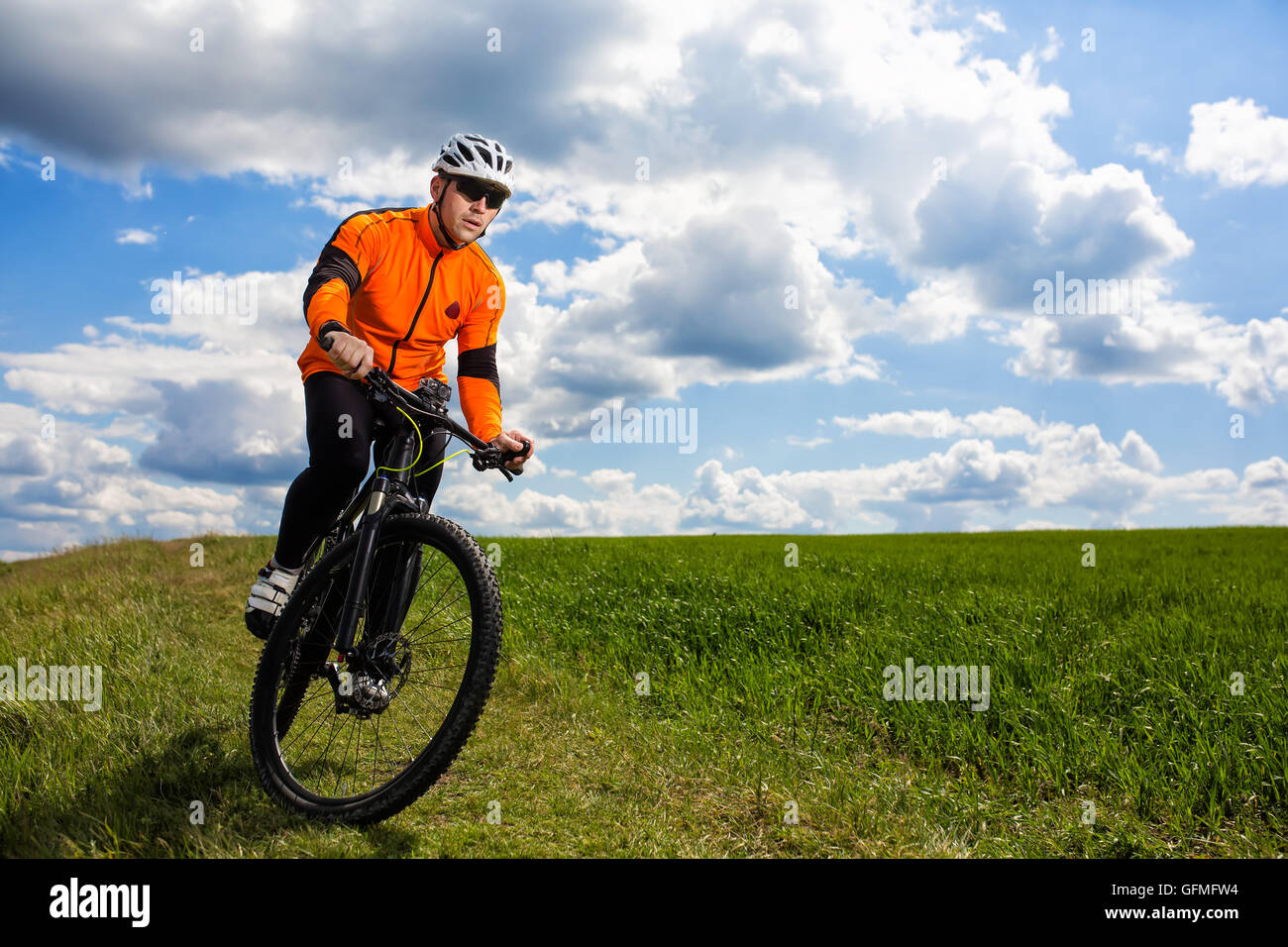 Young man cycling on a rural road through green meadow Stock Photo - Alamy