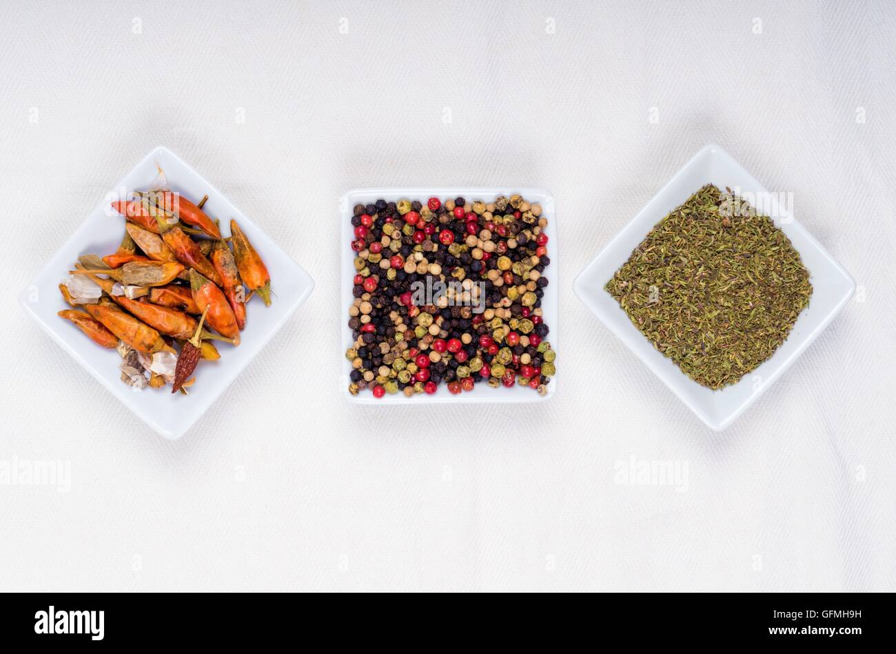 various spices in white bowls of square shape in white background Stock ...