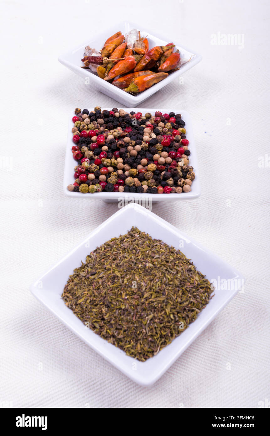 various spices in white bowls of square shape in white background Stock ...