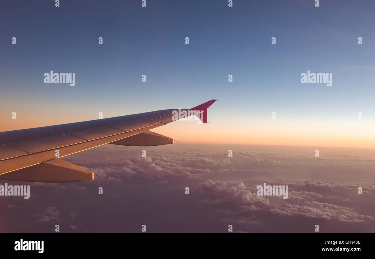 Airplane wing with sunrise in light flare Stock Photo - Alamy