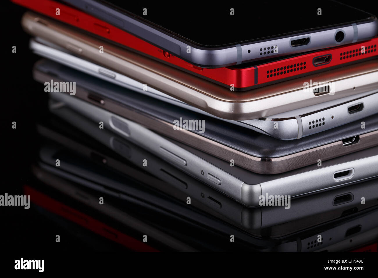 Heap of electronical devices close up - smartphones on black background ...