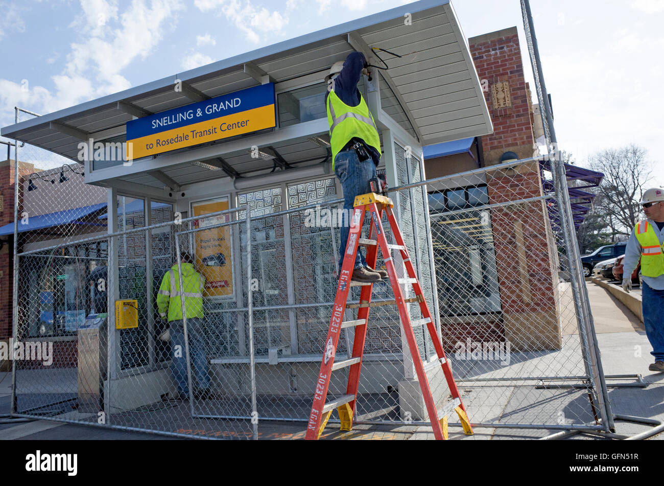 Worker on ladder installing electricity into new rapid transit express ...