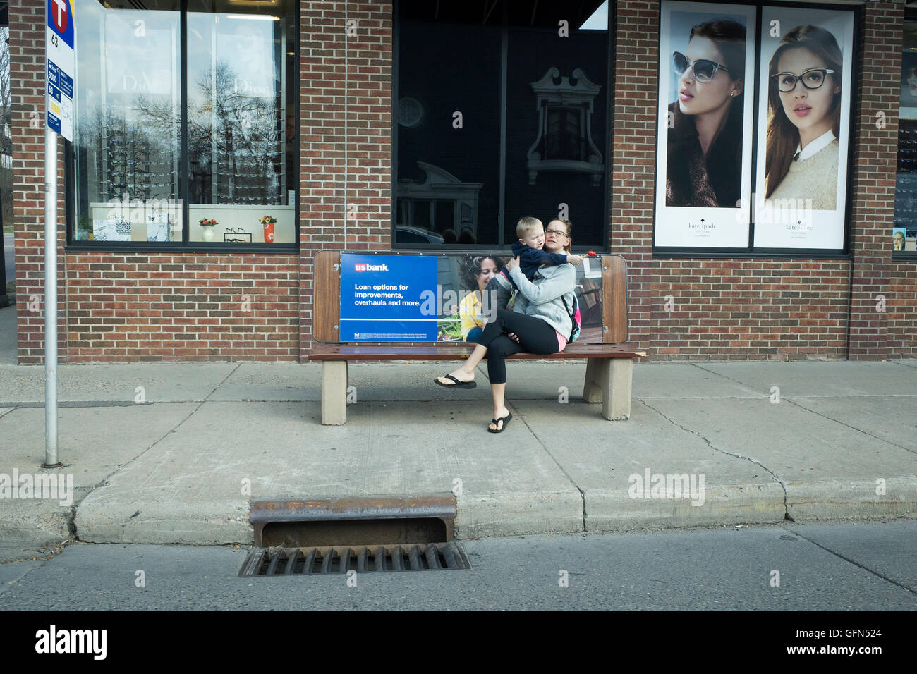 Mom resting on bench trying to hang on to her rambunctious toddler son ...