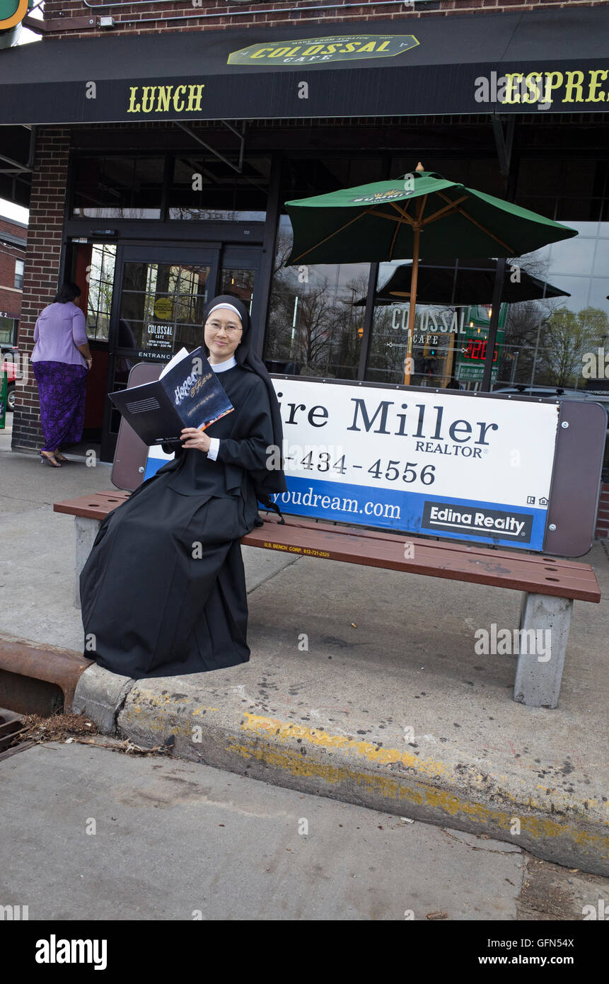 Catholic Nun in her habit waiting for a bus, reading Hopes & Fears ...