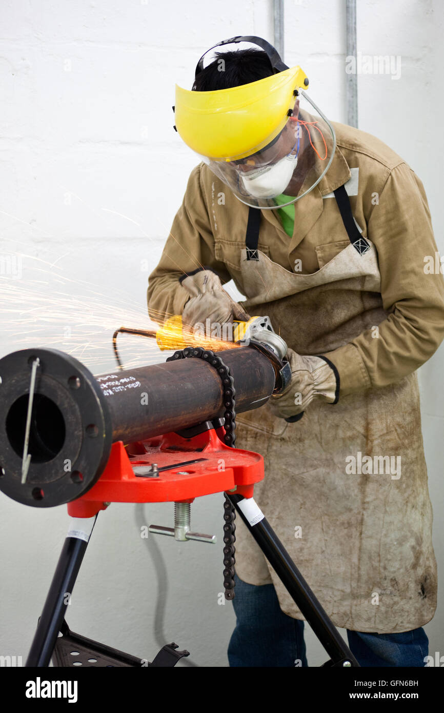 Sanding a tube wearing protective clothes and equipment Stock Photo - Alamy