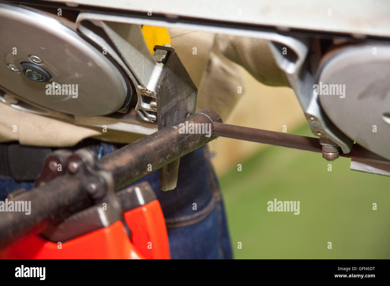 Worker cutting a pipe using a cutting tool Stock Photo - Alamy